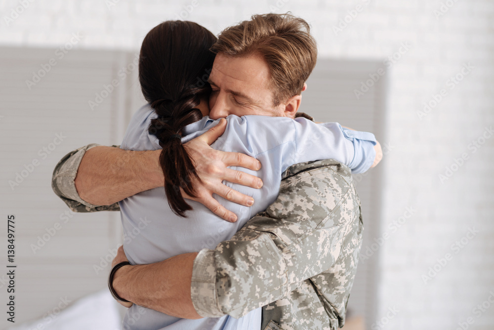 Handsome delighted soldier hugging his wife Stock Photo | Adobe Stock