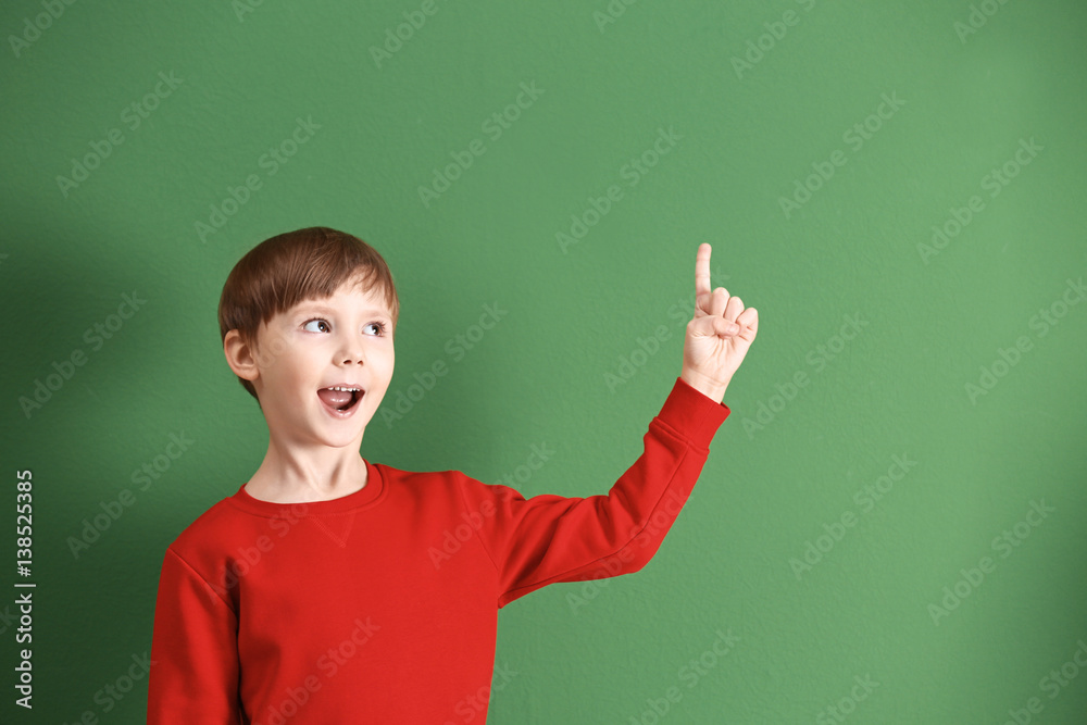 Cute little boy with index finger up on color background Stock Photo ...