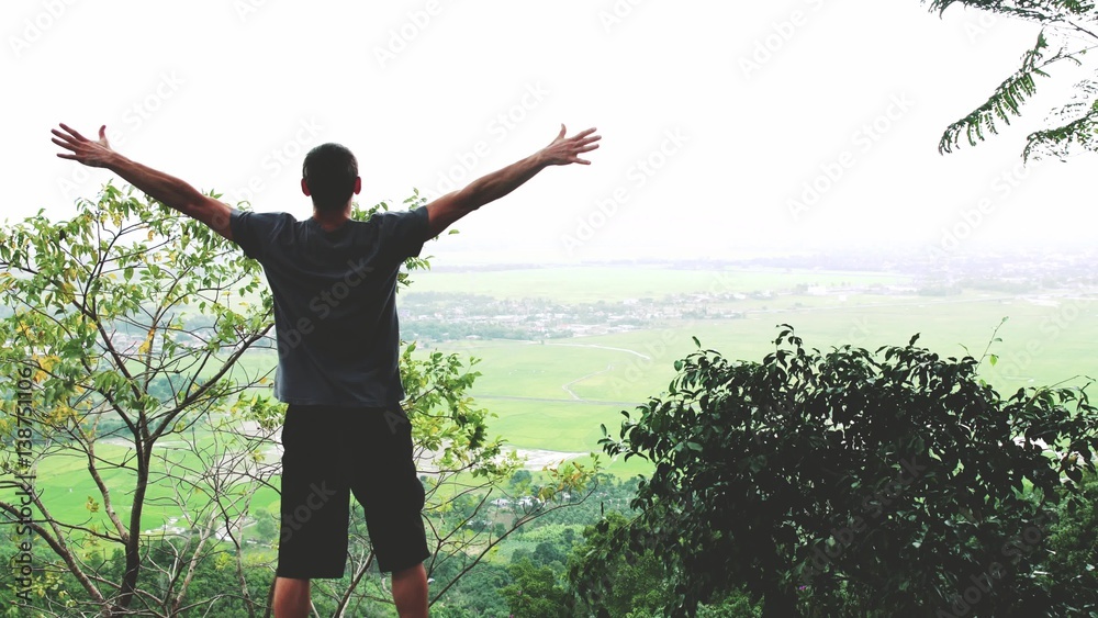 Successful man raising arms after cross track running on summer sunset ...