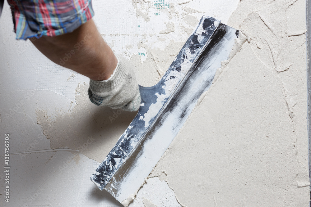 Hand of builder worker with a long spatula Stock Photo | Adobe Stock