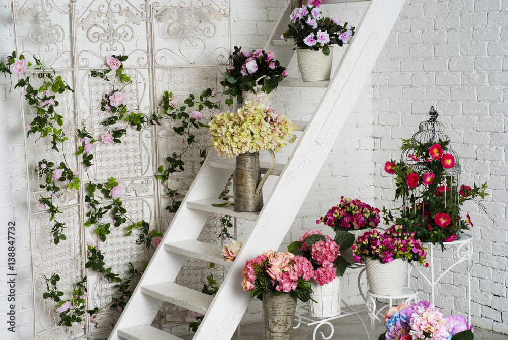 Vintage bright interior living room with flowers in vases, stairs and ...