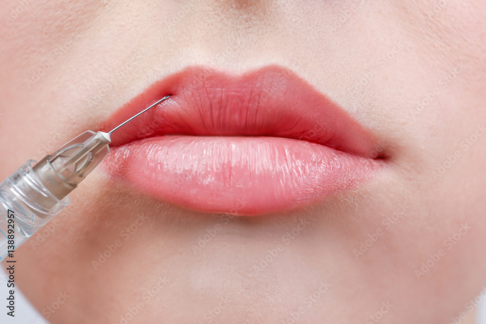 Beautiful young woman receiving filler injection in lips, closeup Stock ...