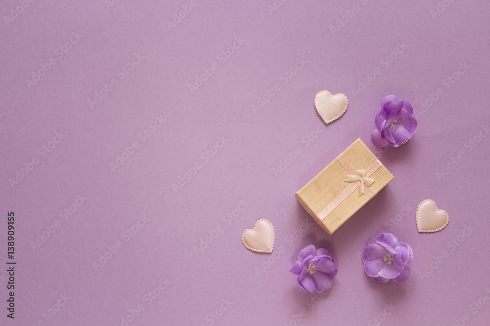 Violet background with gift box, purple flowers and hearts. Space for ...