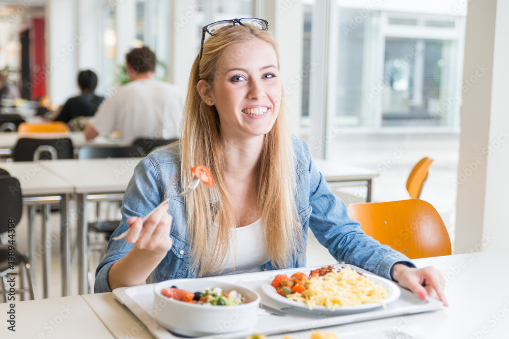 Studentin isst in Mensa Stock-Foto | Adobe Stock