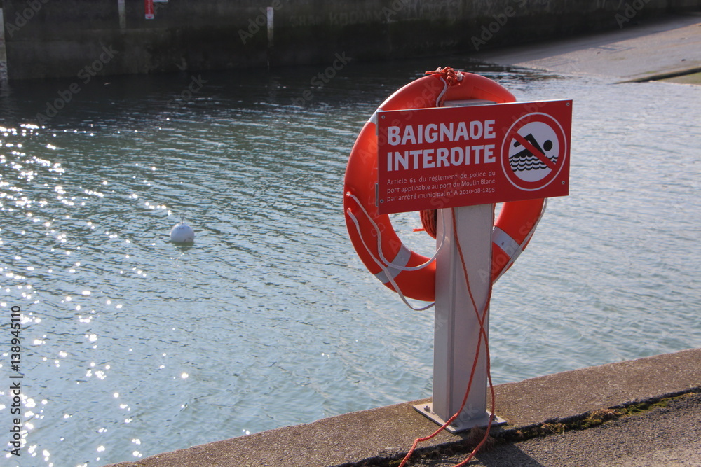 Panneau baignade interdite et bouée de sauvetage sur un quai Stock ...
