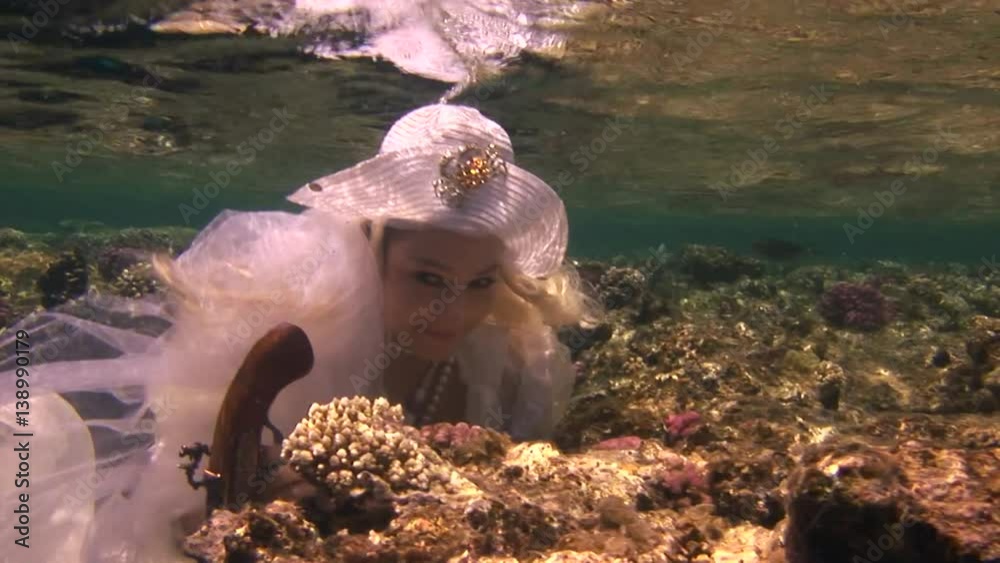 Model in white costume of pirate underwaterin Red Sea. Filming a movie ...