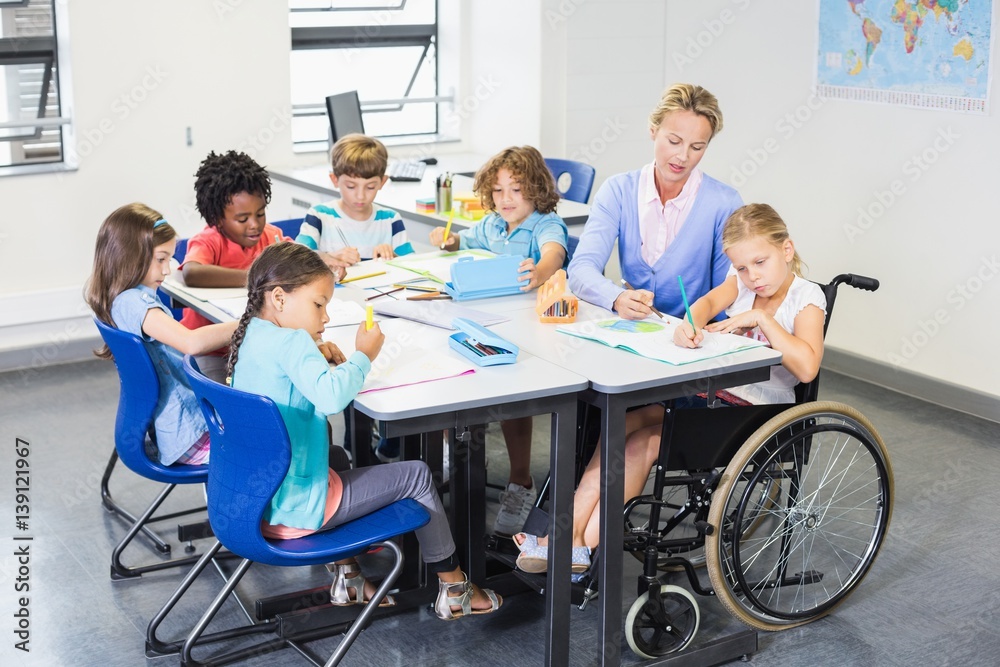Teacher helping kids with their homework in classroom Stock Photo ...