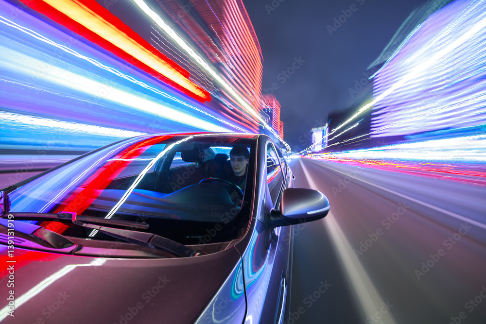 Blurred urban look from fast driving car to back side and driver at ...