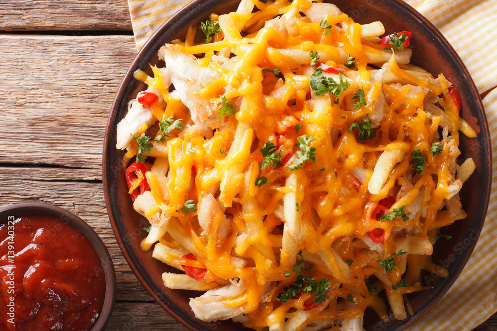 french fries with cheddar cheese and chicken meat close-up. horizontal ...