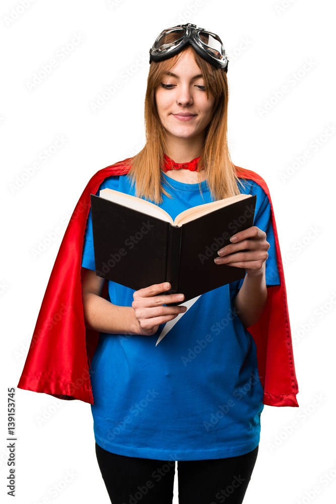 Pretty superhero girl reading book Stock Photo | Adobe Stock