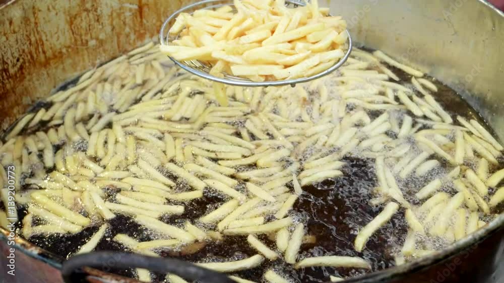 fries cook in boiling oil, harmful food, fat dripping from fries ...