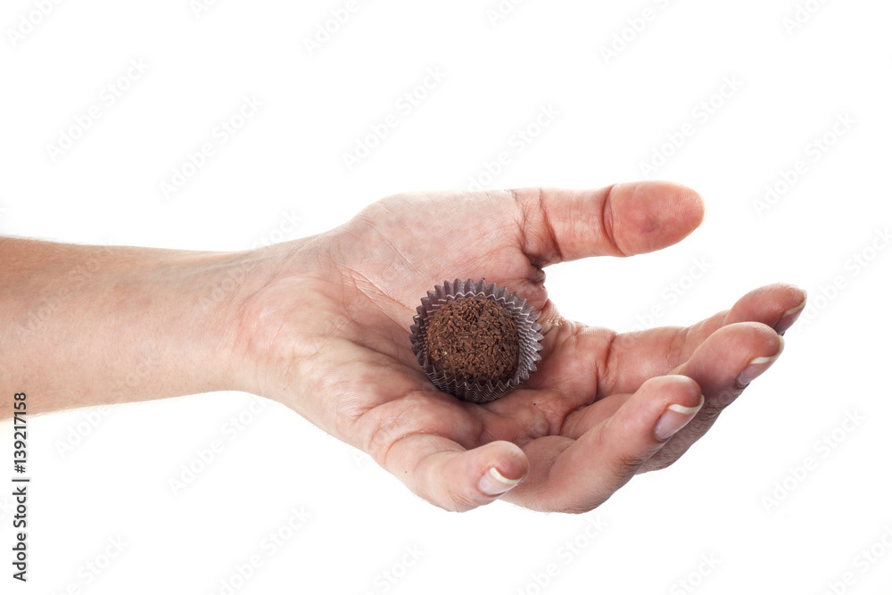 Hand holding a traditional candy from Brazil called brigadeiro over ...