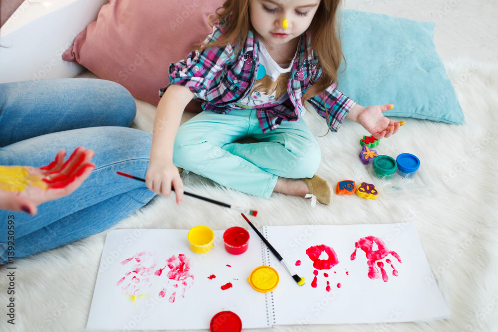 Charming little girl plays with yellow and red paints Stock Photo ...