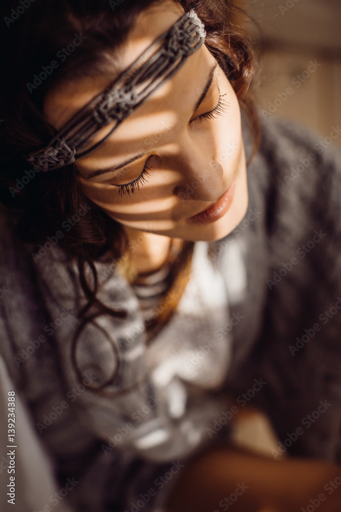 Look from above at beautiful woman with rope wreath and rays of sun on ...