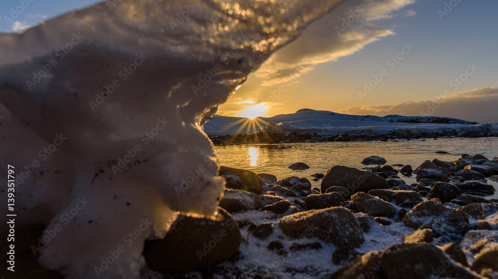 Sunrise over a river with an natural ice sculptur in the foreground ...
