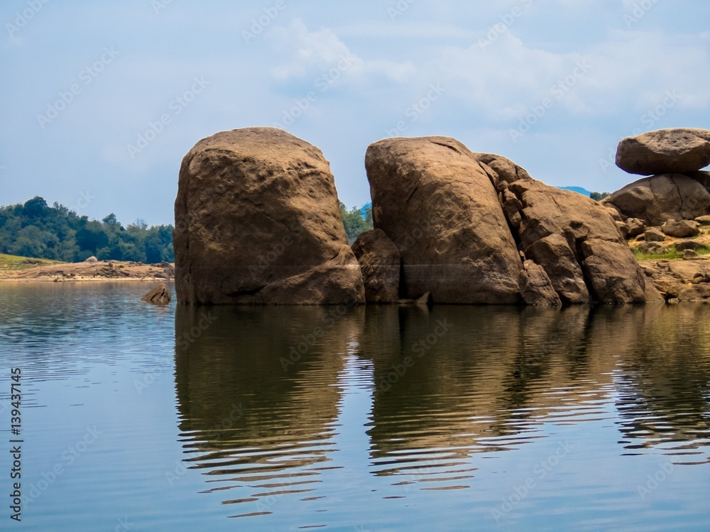 Rock formed island yellow stone reflection on water in Inginiyagala ...