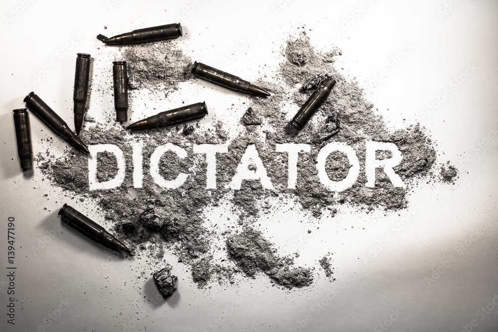 Dictator word written in ash, dirt, dust with bullets around as ...