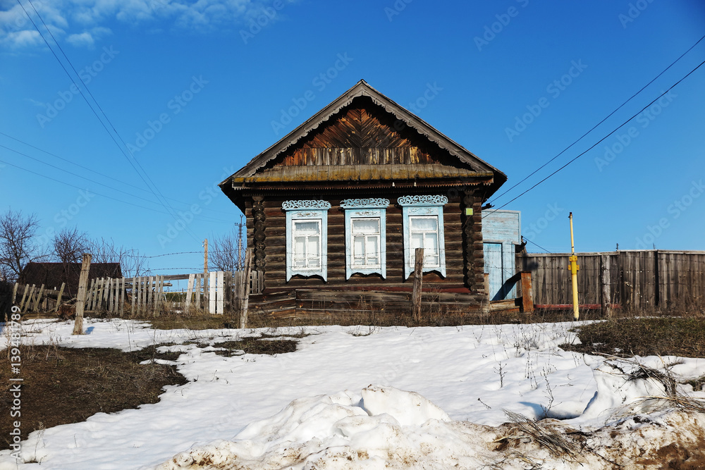 Old log house in the remote Russian village in the early spring against ...