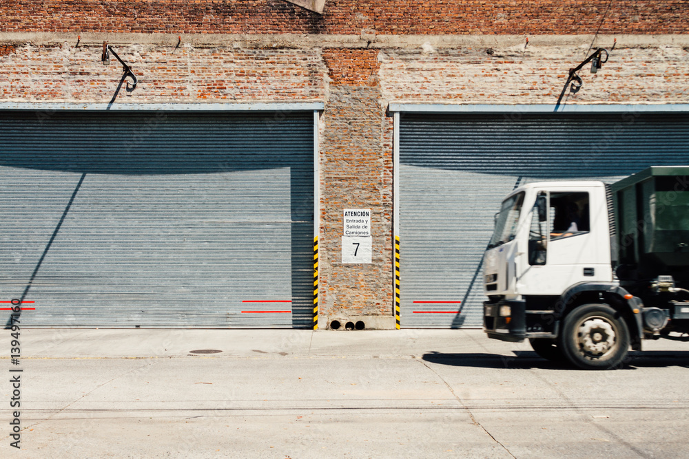 Entrance to a factory with sign "Attention. Entrance and exit of trucks ...