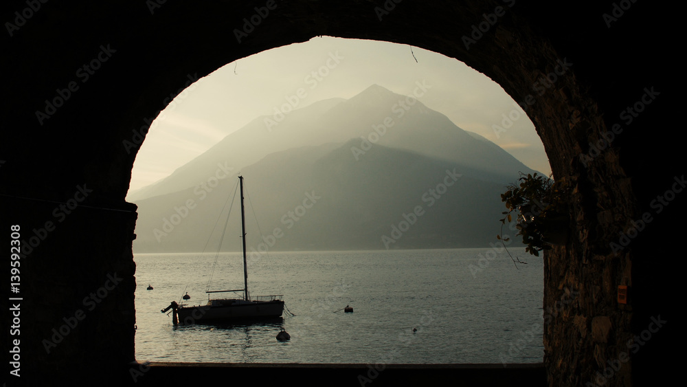 Boat on Lake Como at the sunset, view through arch . Silver linings in ...