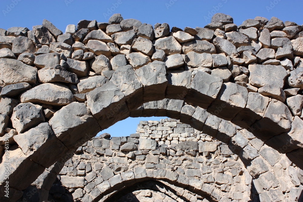 Desert castle Qasr al Azraq in Jordan, Stone arches of basalt rock ...