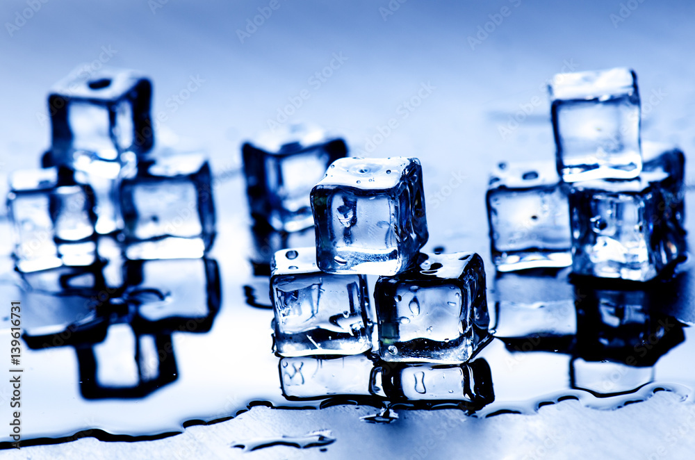 Iced cubes melting on a blue table with reflection. Water. Melting of ...