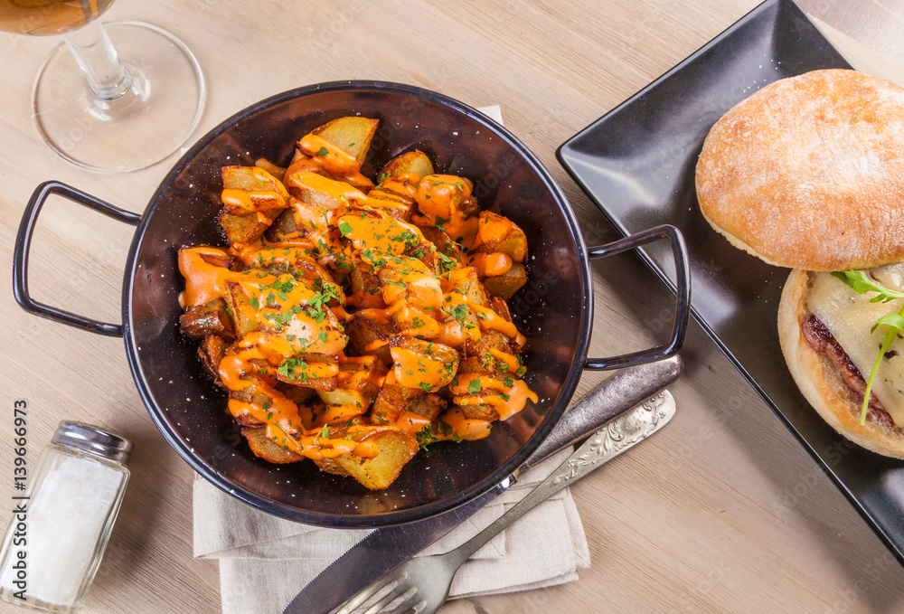 Patatas bravas, spicy potatoes, a typical Spanish dish with fried ...