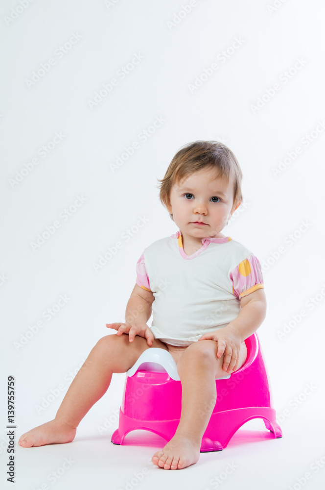 Little smiling girl sitting on a pot. Isolated on white background ...