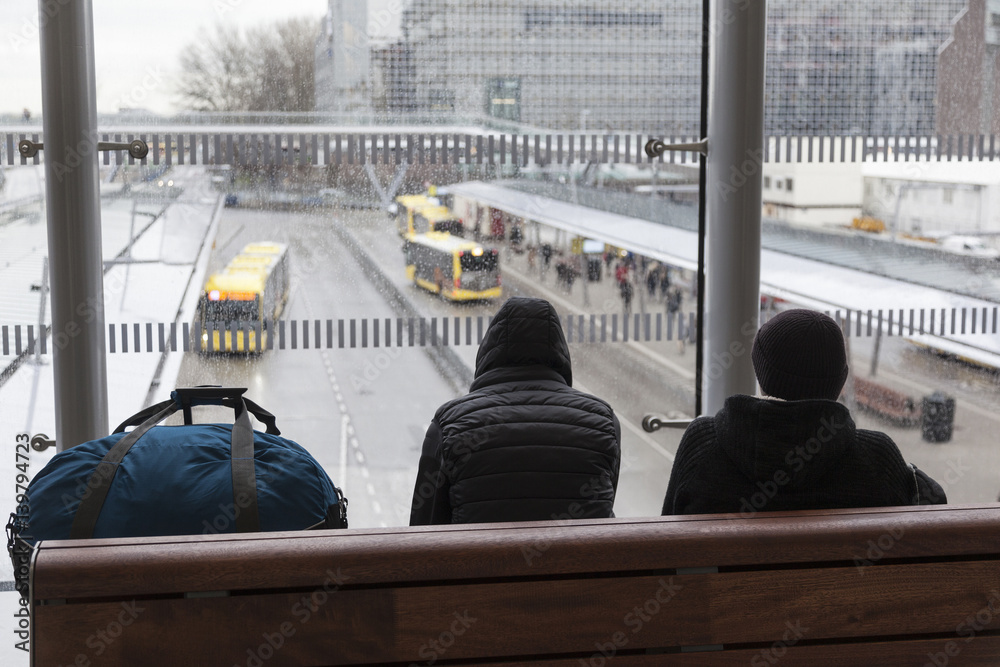 passengers wait inside station for bus on rainy day in dutch city of ...