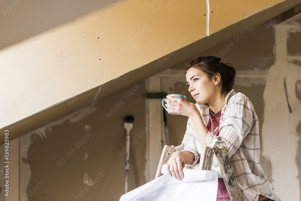 Young woman renovating her new home, holding construction plan Stock ...