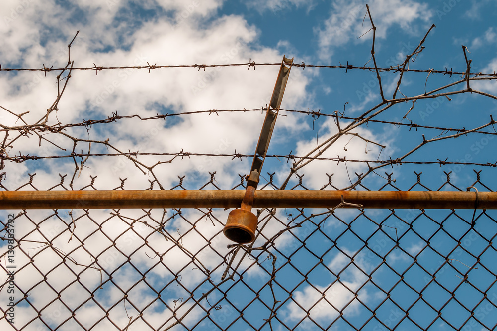Abstract chain link fence with barbed wire. Broken chain steel fence ...