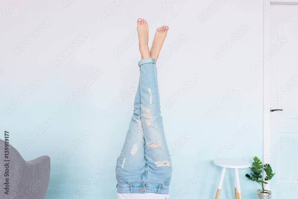 Women’s legs in blue jeans with white pedicure on a blue and white ...