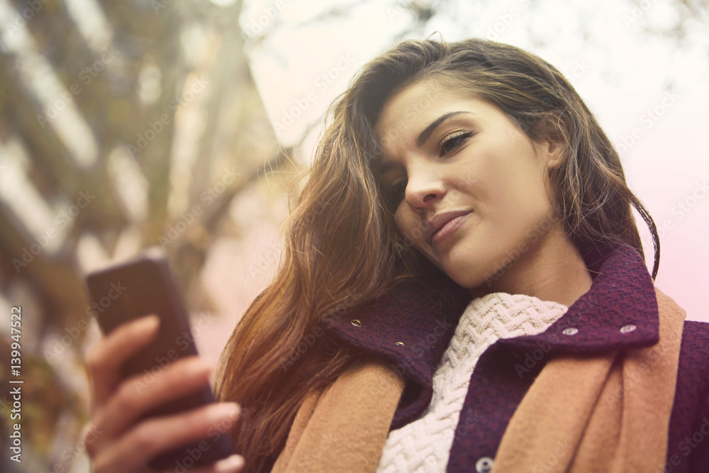 Girl checking her phone Stock Photo | Adobe Stock