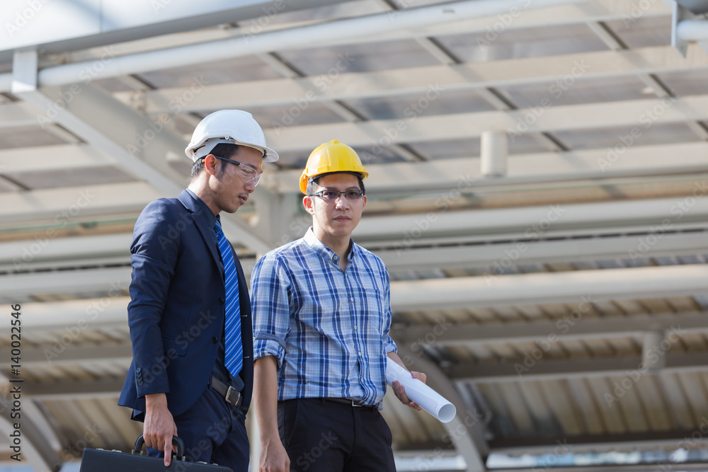 Engineer and Foreman outside office with yellow, white helmet point to ...