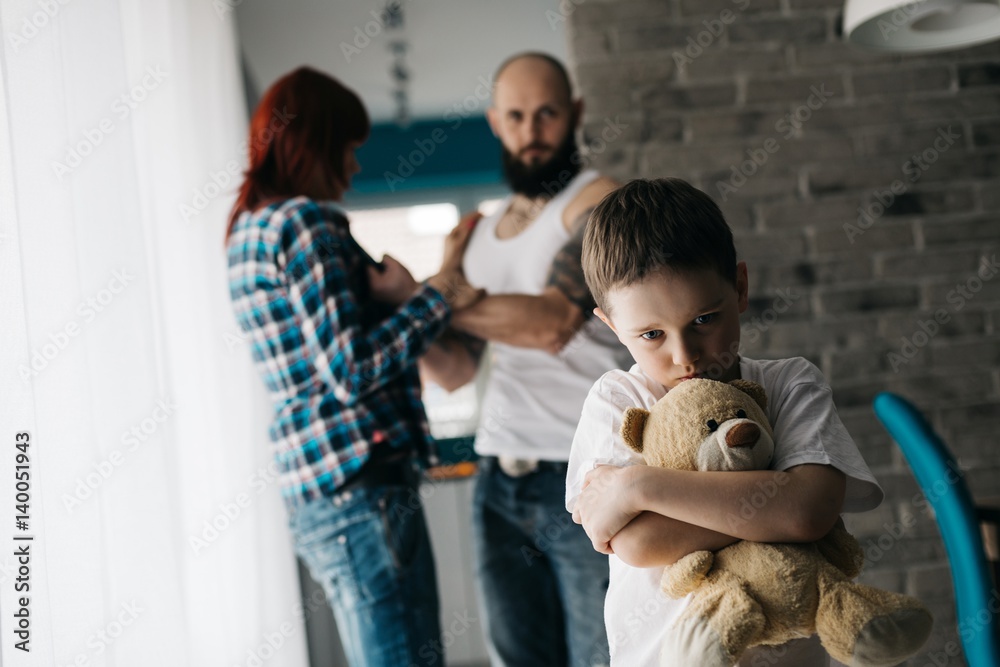 Sad child hugging his teddy bear during parents quarrel. Stock Photo ...