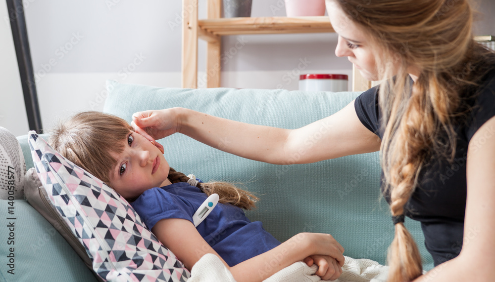 Sick little girl lying in bed mother checking her temperature Stock Photo | Adobe Stock