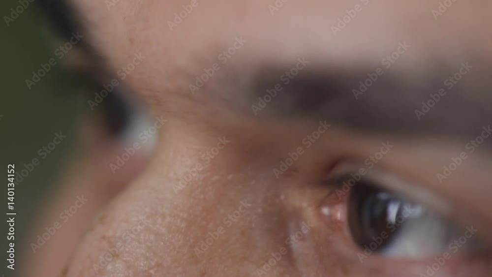 Male severe glance brown eyes focused forward looking and blinking ...