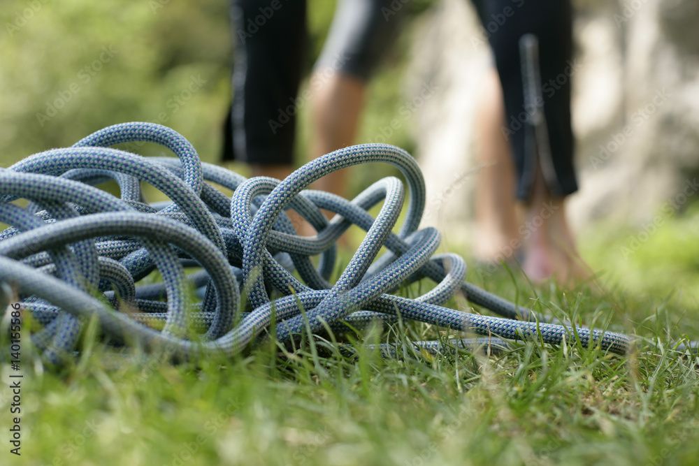 Climbing rope lying on the ground in front of a person (part of ...