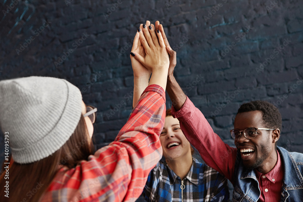 International group of three stylish and creative young people laughing ...