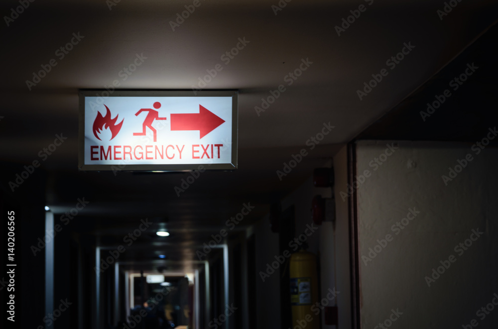 emergency exit sign light showing way to escape in dark path way at ...