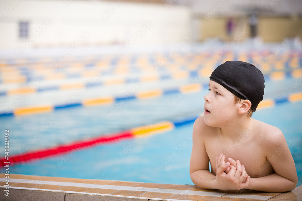 Portrait of a cute little boy ready to dive in the sport swimming pool ...