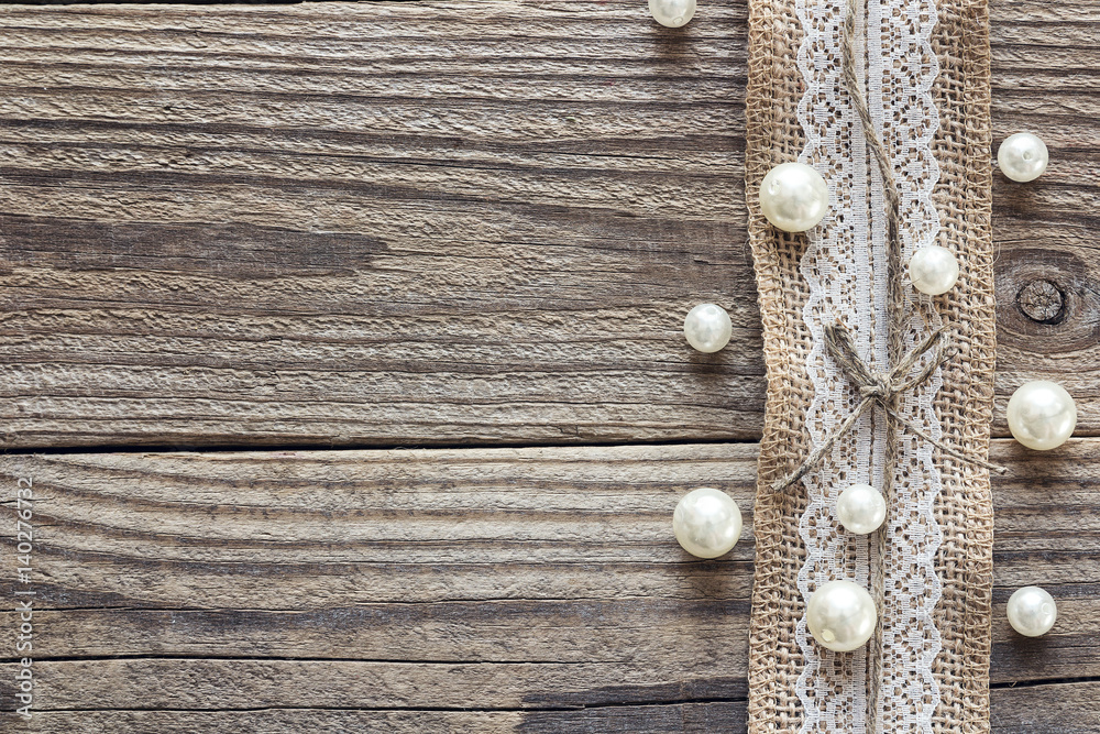 Border of burlap with white lace and beads on old wooden table. Design ...