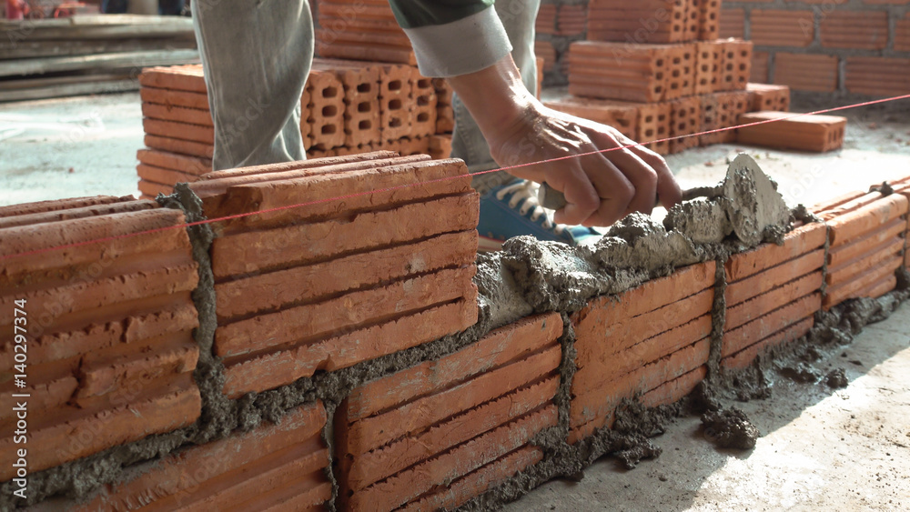 Bricklayer worker installing brick masonry on exterior wall Stock Photo ...
