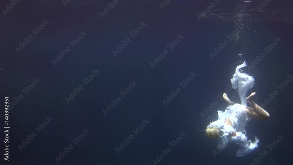 Young girl model free diver underwater white angel costume poses in Red ...