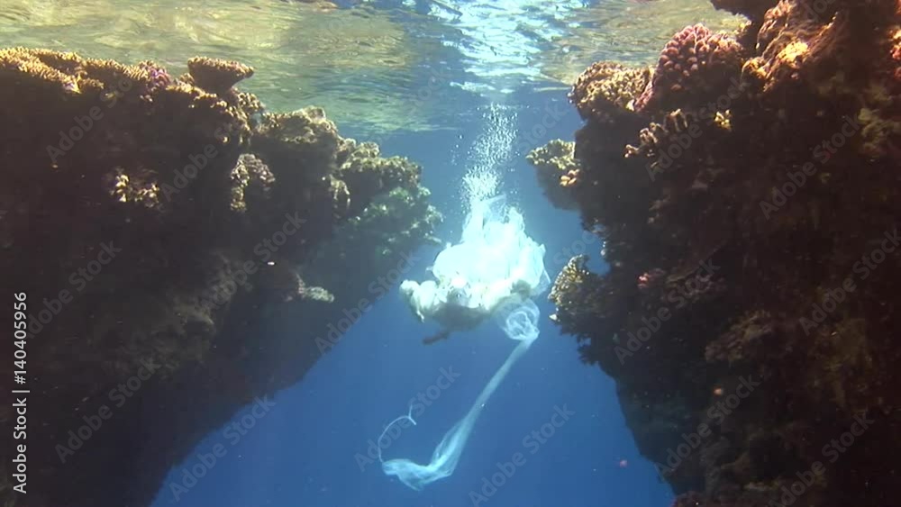 Underwater model free diver in costume pirate swims in clean water in ...