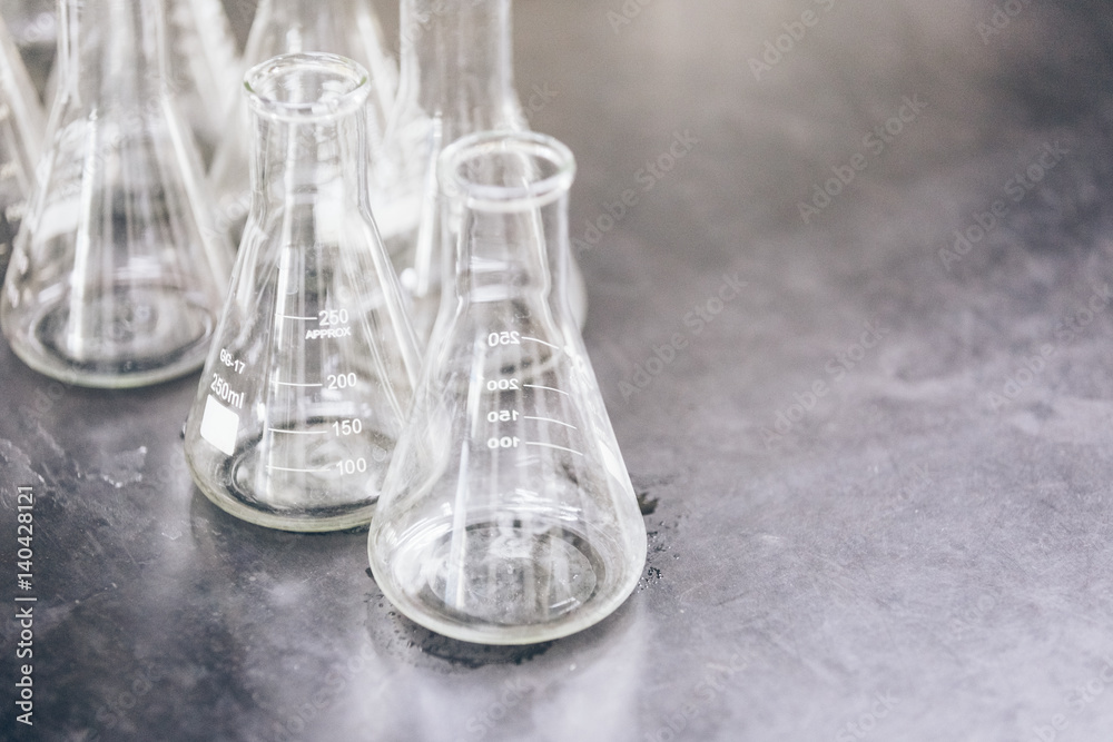 detail shot of beakers and equipment on table in factory laboratory ...