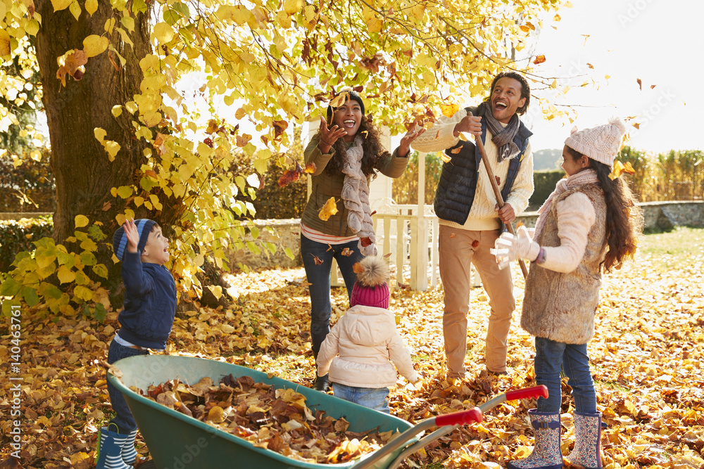 Children Helping Parents To Collect Autumn Leaves In Garden Stock Photo ...