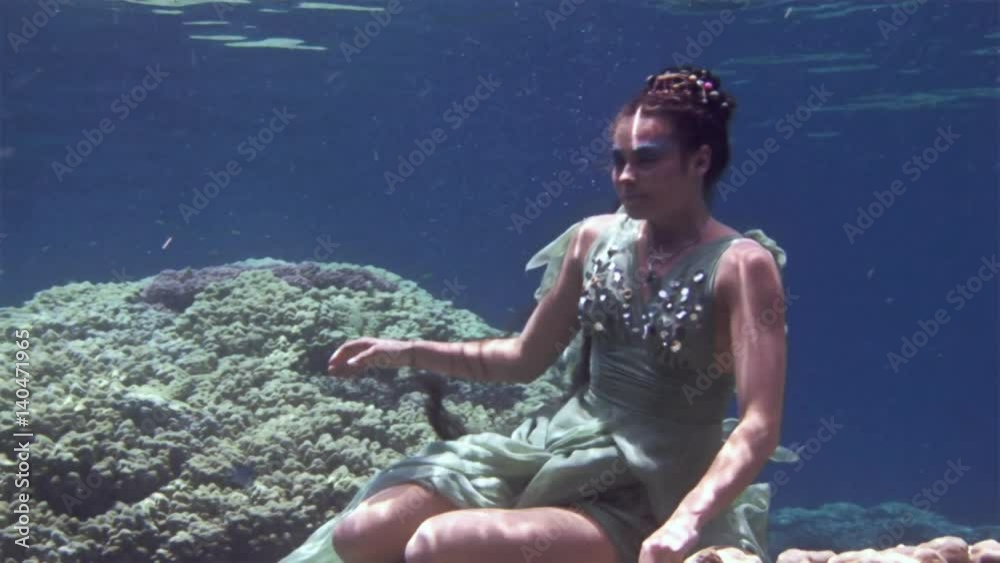 Underwater model free diver poses for camera on background of corals in ...