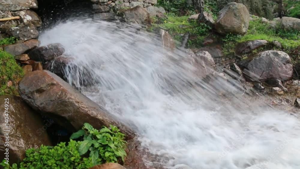 Water stream coming out of a traditional old water mill in full ...