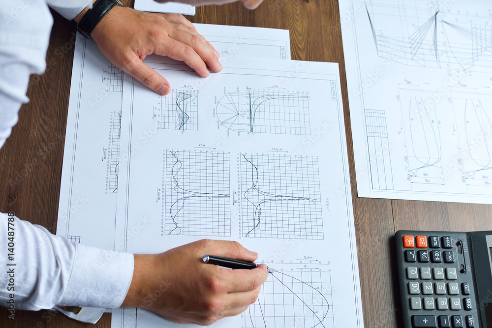 Mechanical engineer at work. Technical drawings. Paper with technical ...